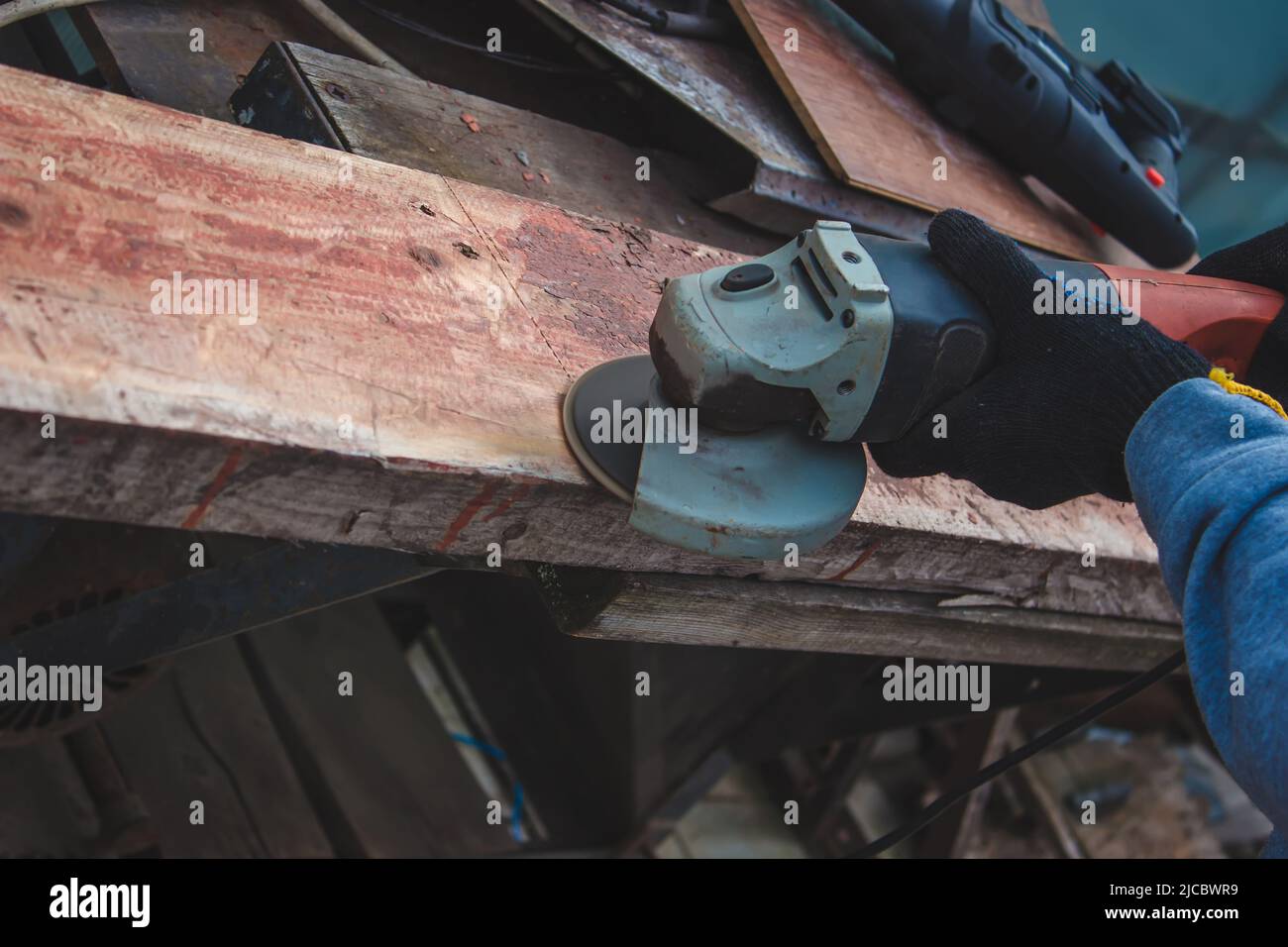 a man is grinding a board. Removing old paint from boards. Carpentry ...