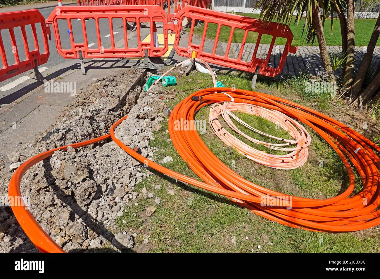 Trench installation in grass verge coils of fibre optics cables for new ...