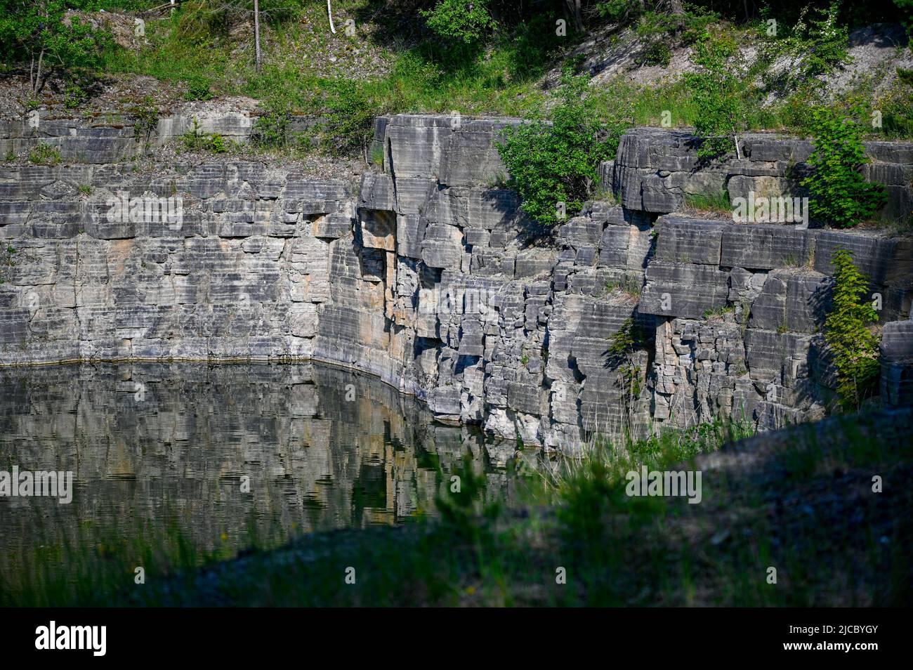 open quarry filled with water with high wall Stock Photo - Alamy