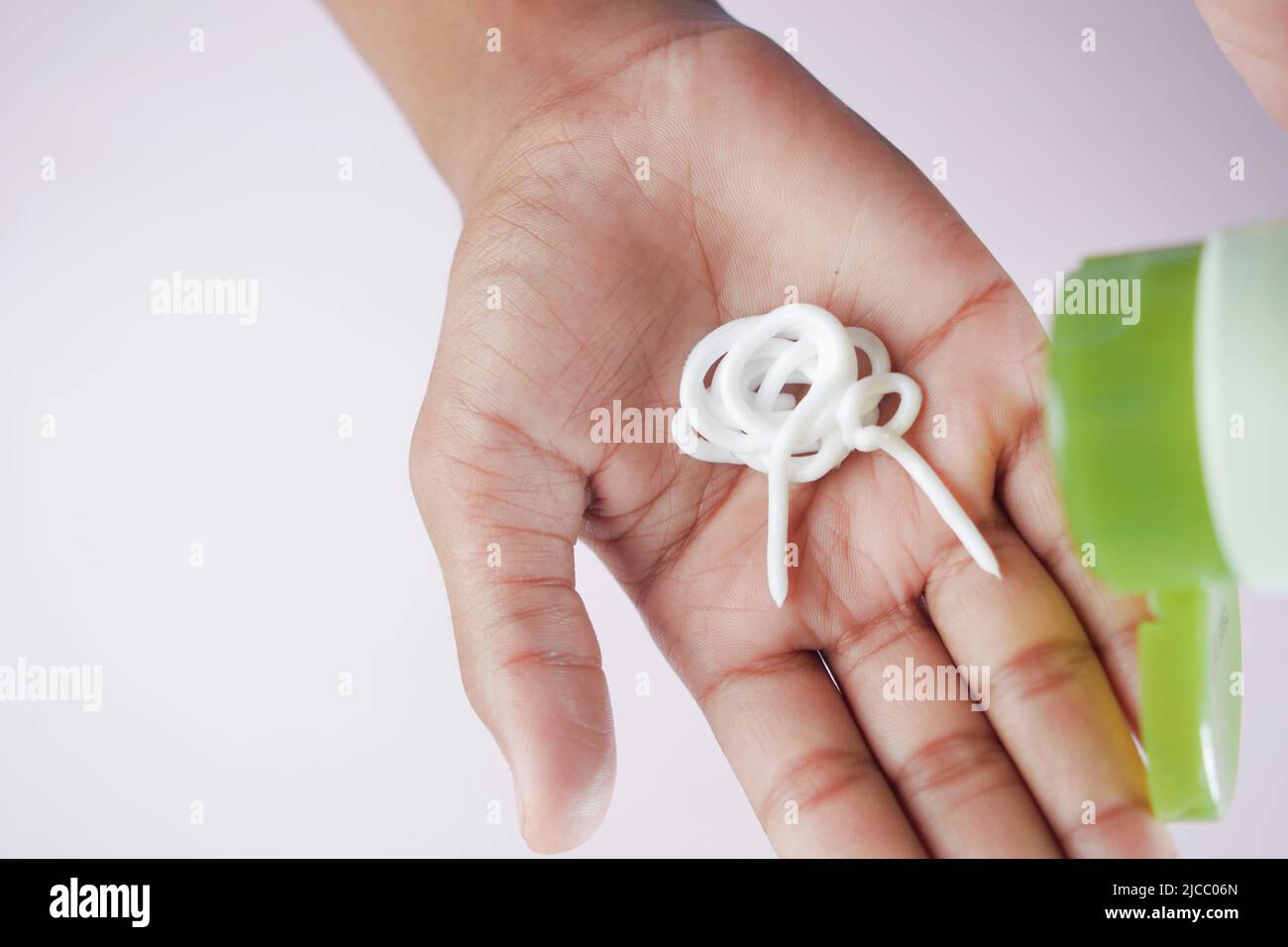 young man pouring moisturizing cream from a container Stock Photo - Alamy