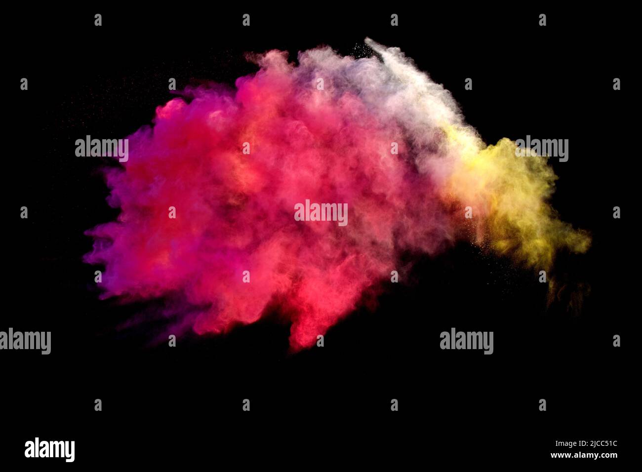 Vivid multi-coloured forms of powder paint explode in front of a black ...
