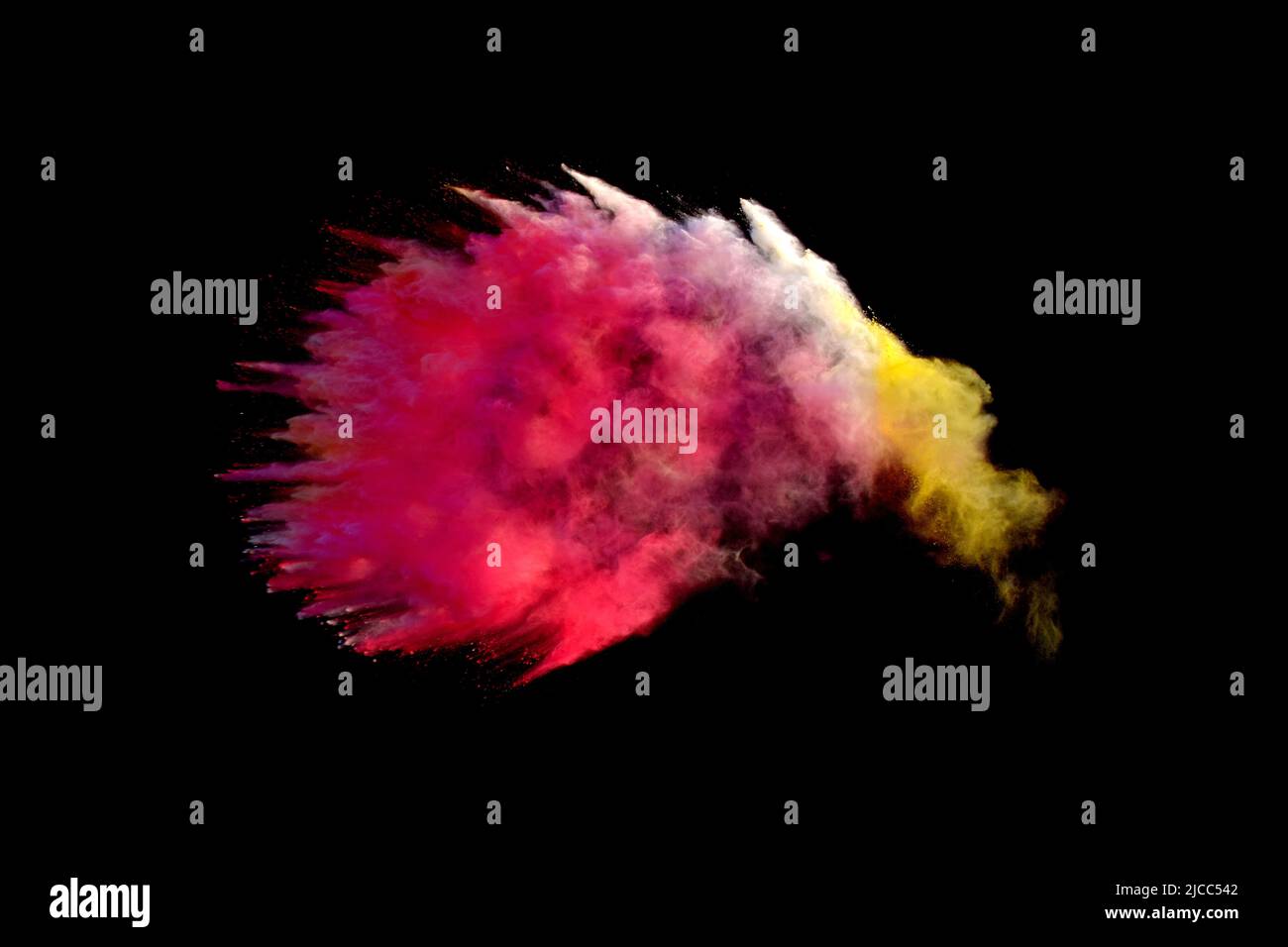 Vivid multi-coloured forms of powder paint explode in front of a black ...
