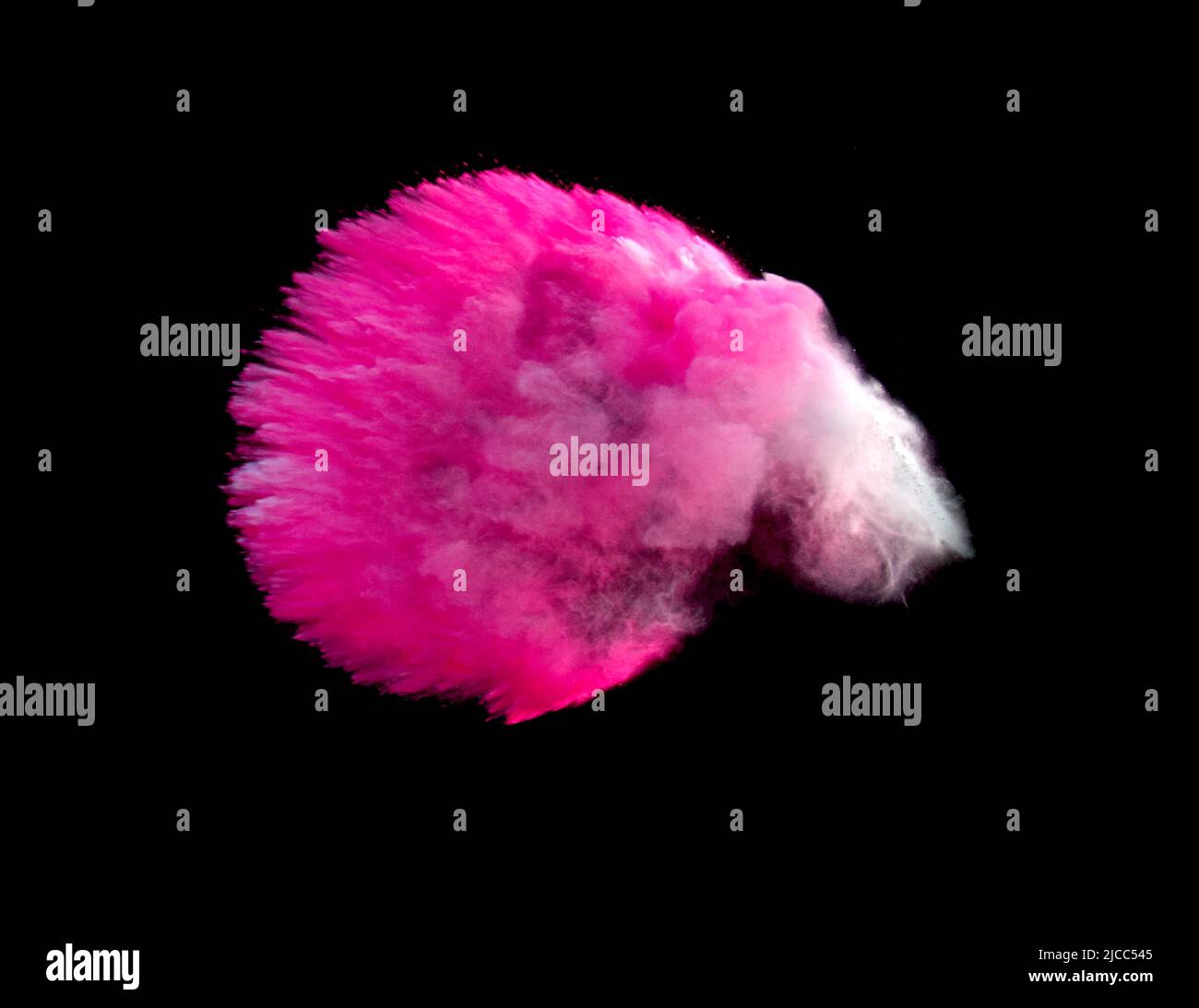 Vivid multi-coloured forms of powder paint explode in front of a black ...