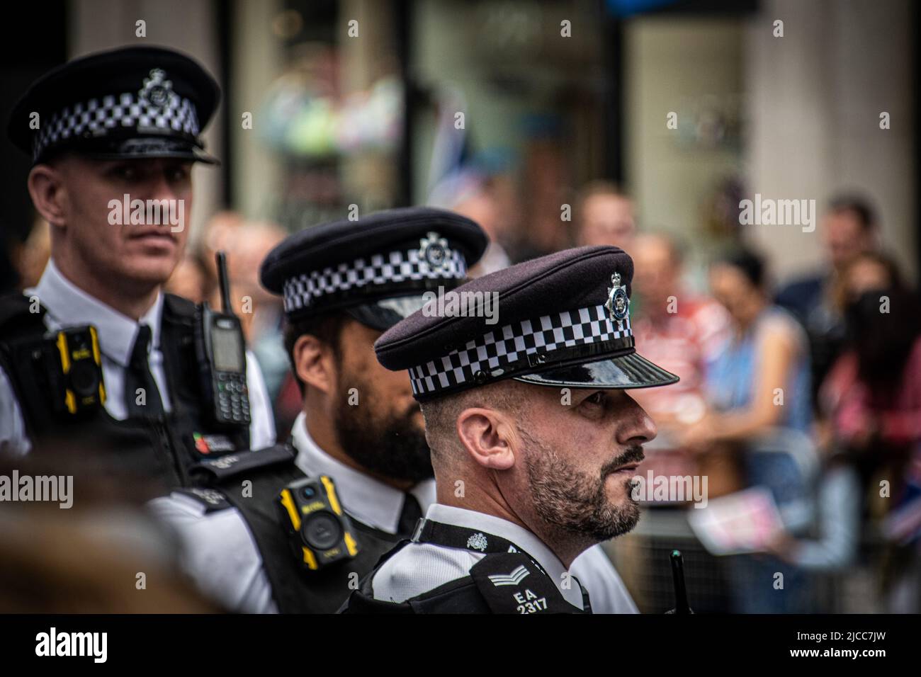 Three Police Officers watching the crowd Stock Photo - Alamy