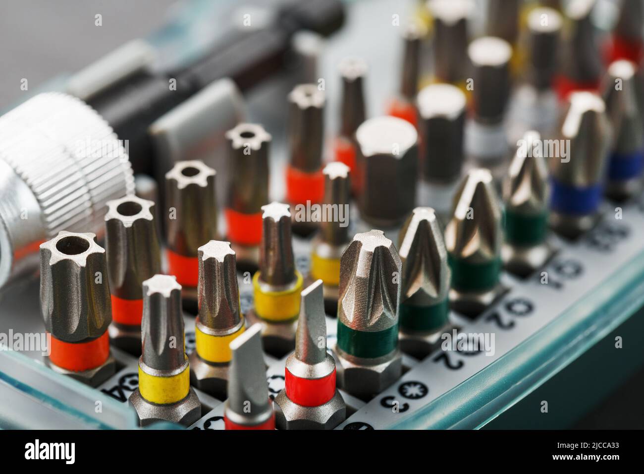 A set of metal power bits in a box on a gray background, for repair and ...