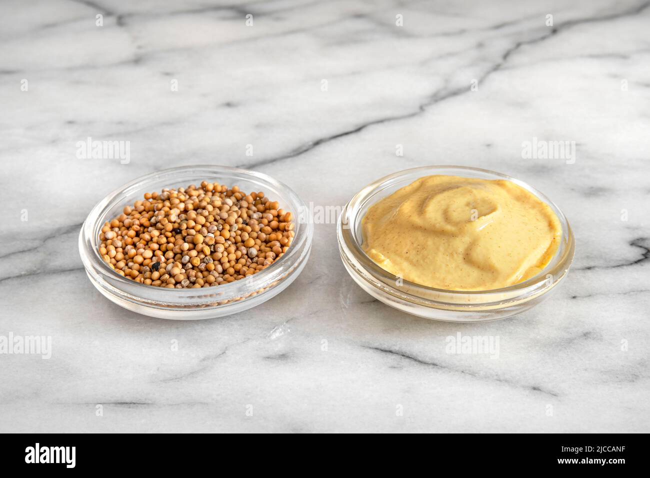 Close-up of mustard seeds and yellow mustard in glass bowls Stock Photo ...