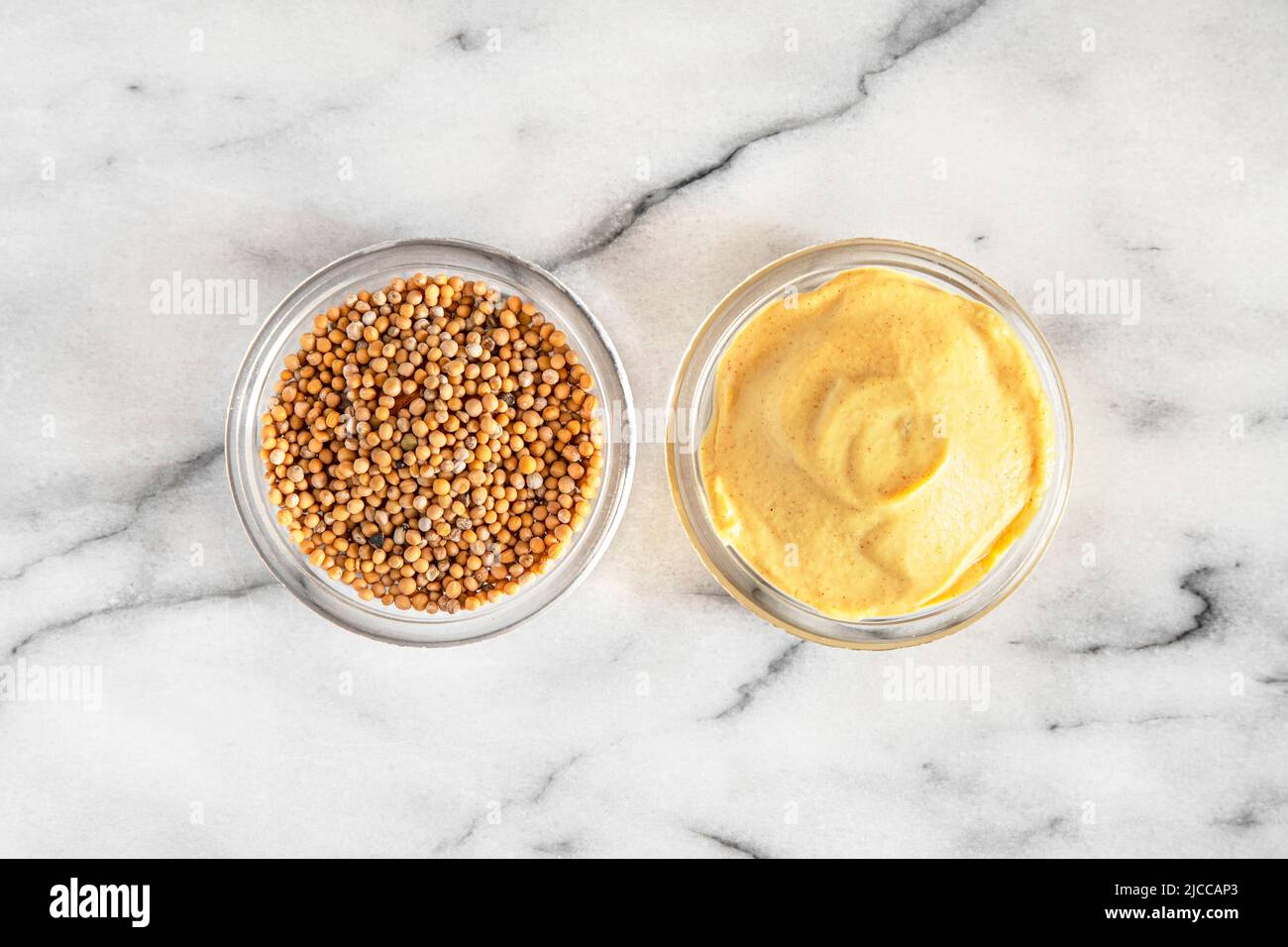 Close-up of mustard seeds and yellow mustard in glass bowls Stock Photo ...
