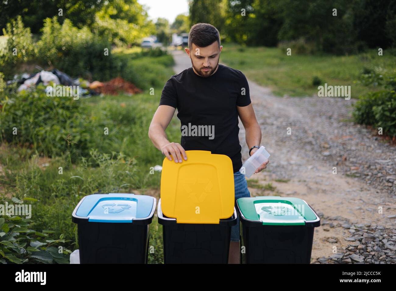 Man throwing plastic bag into recycling bin on back yard. Different ...