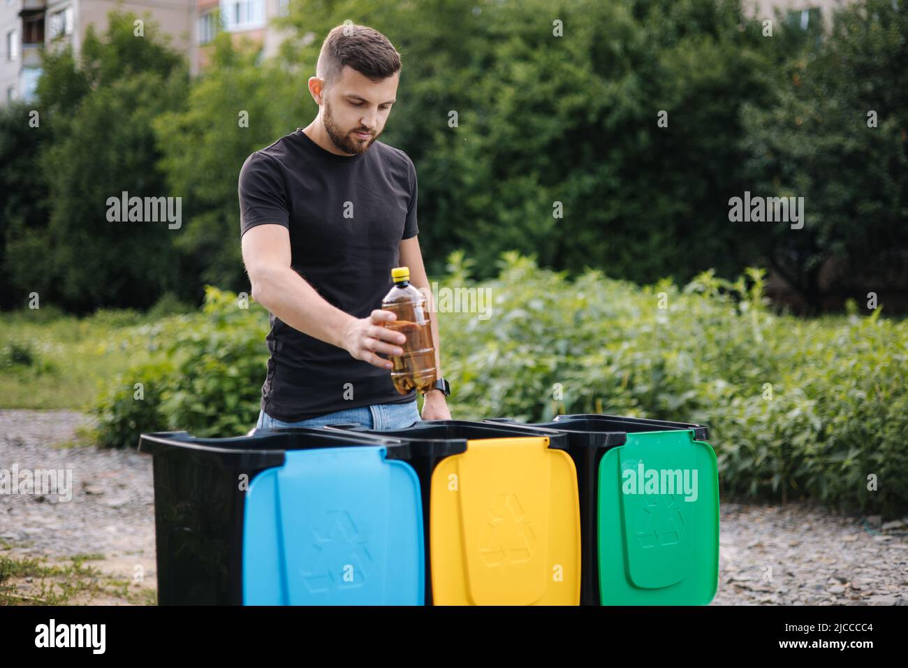 Close-up of human hand throwing empty plastic water bottle in recycling ...