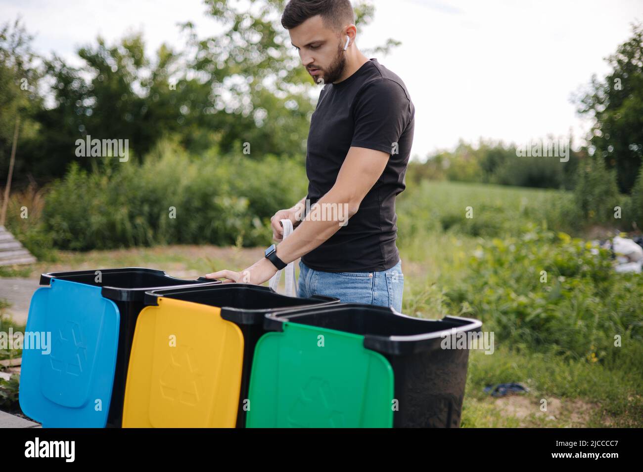 Man with eco package for garbage bring rubbish to recycling bins ...