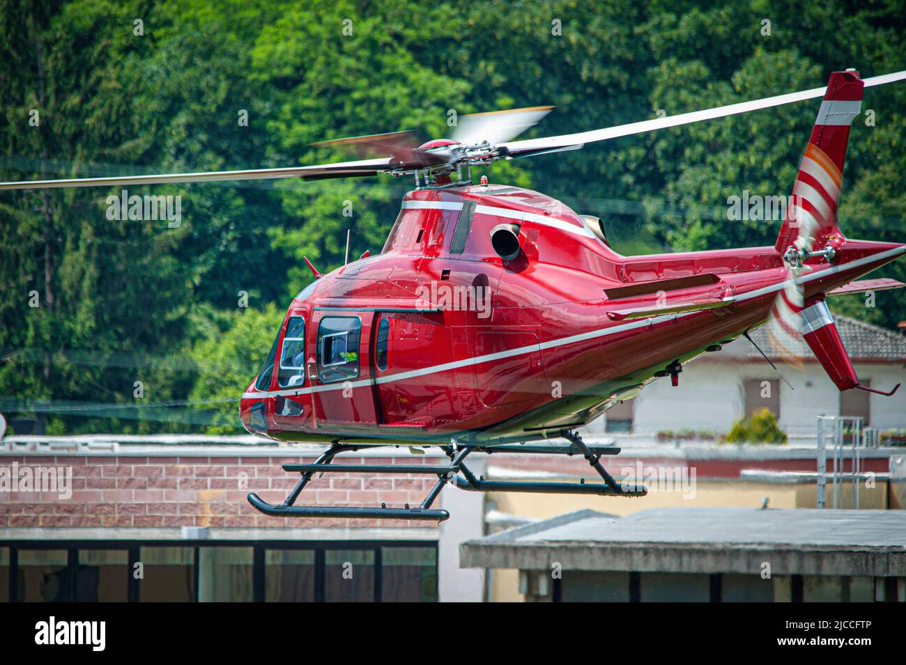 red helicopter being landed in the urban area Stock Photo - Alamy