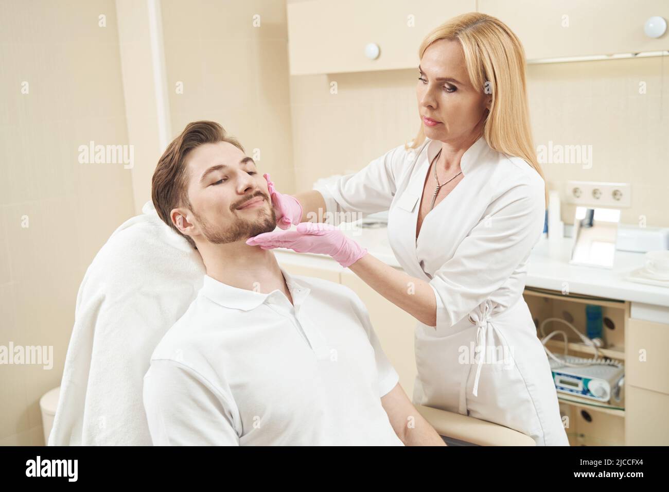 Beautician in aesthetic clinic performing face visual inspection Stock ...