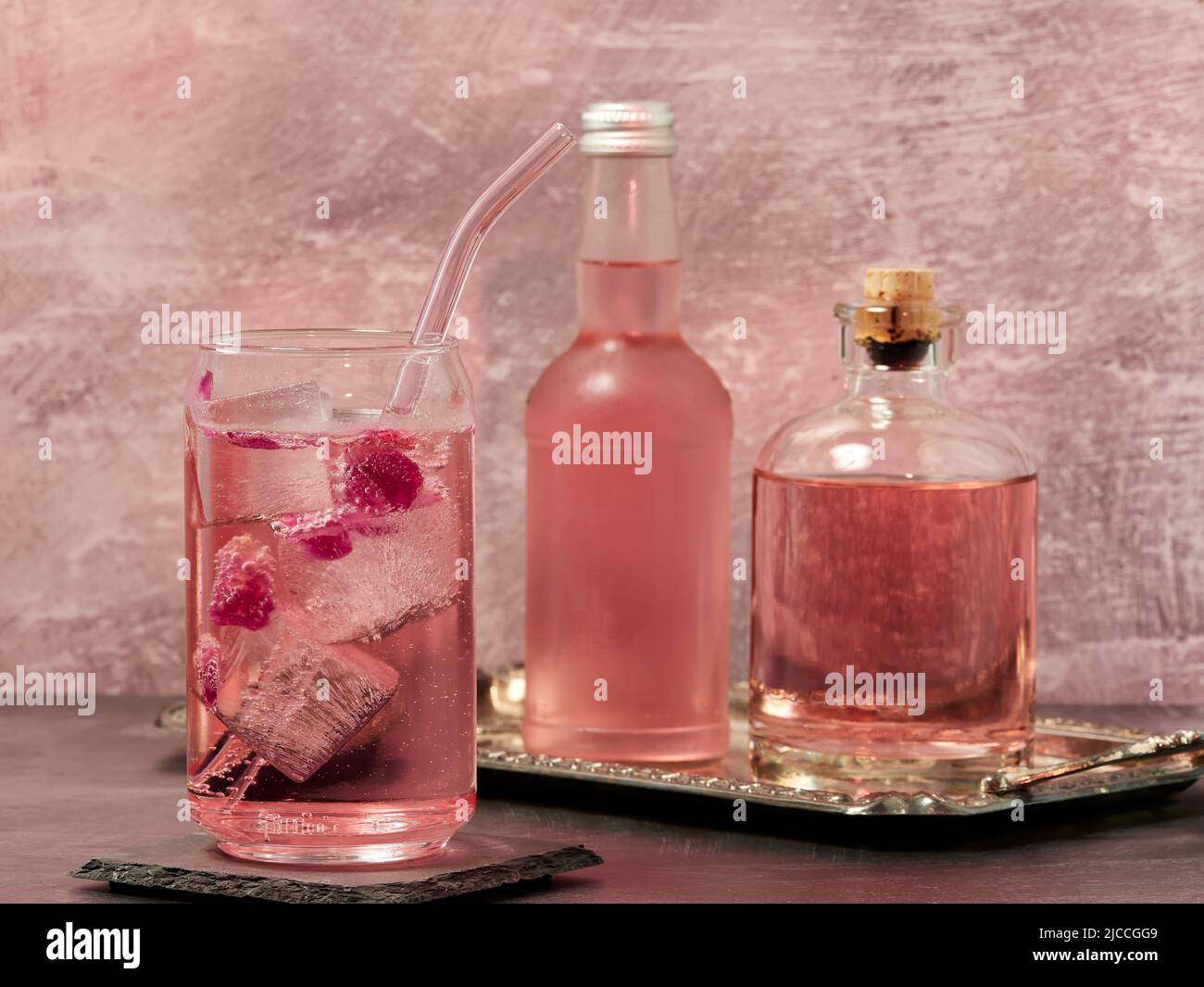 A glass of pink gin and tonic, a bottle of rose lemonade and a bottle ...