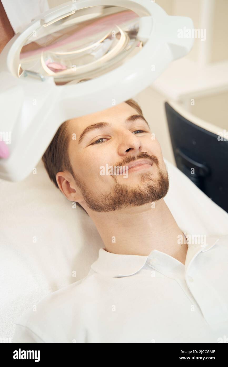 Satisfied Caucasian male on couch staring up before beauty procedure ...