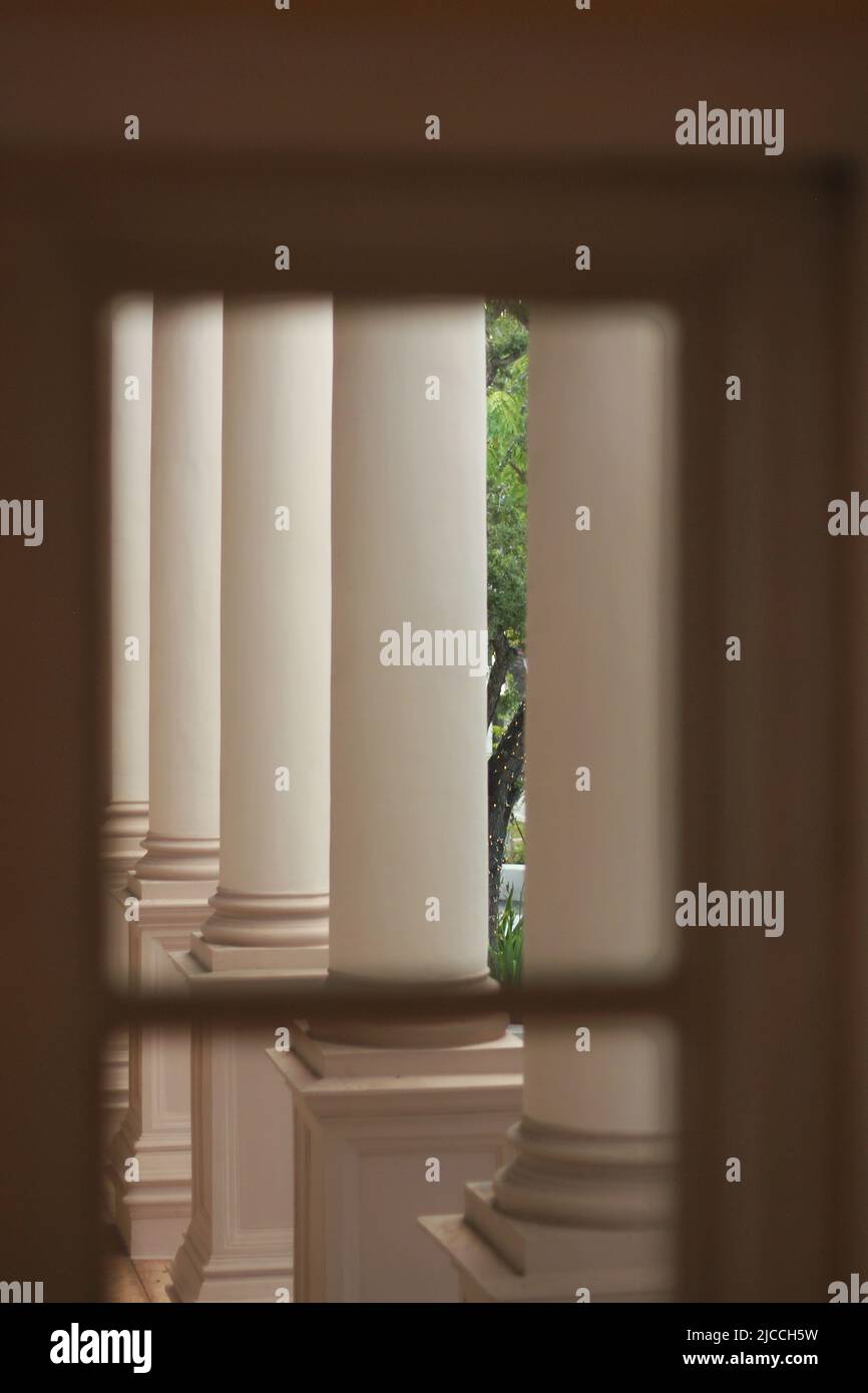 A view thru a window of a colonnade of columns Stock Photo - Alamy