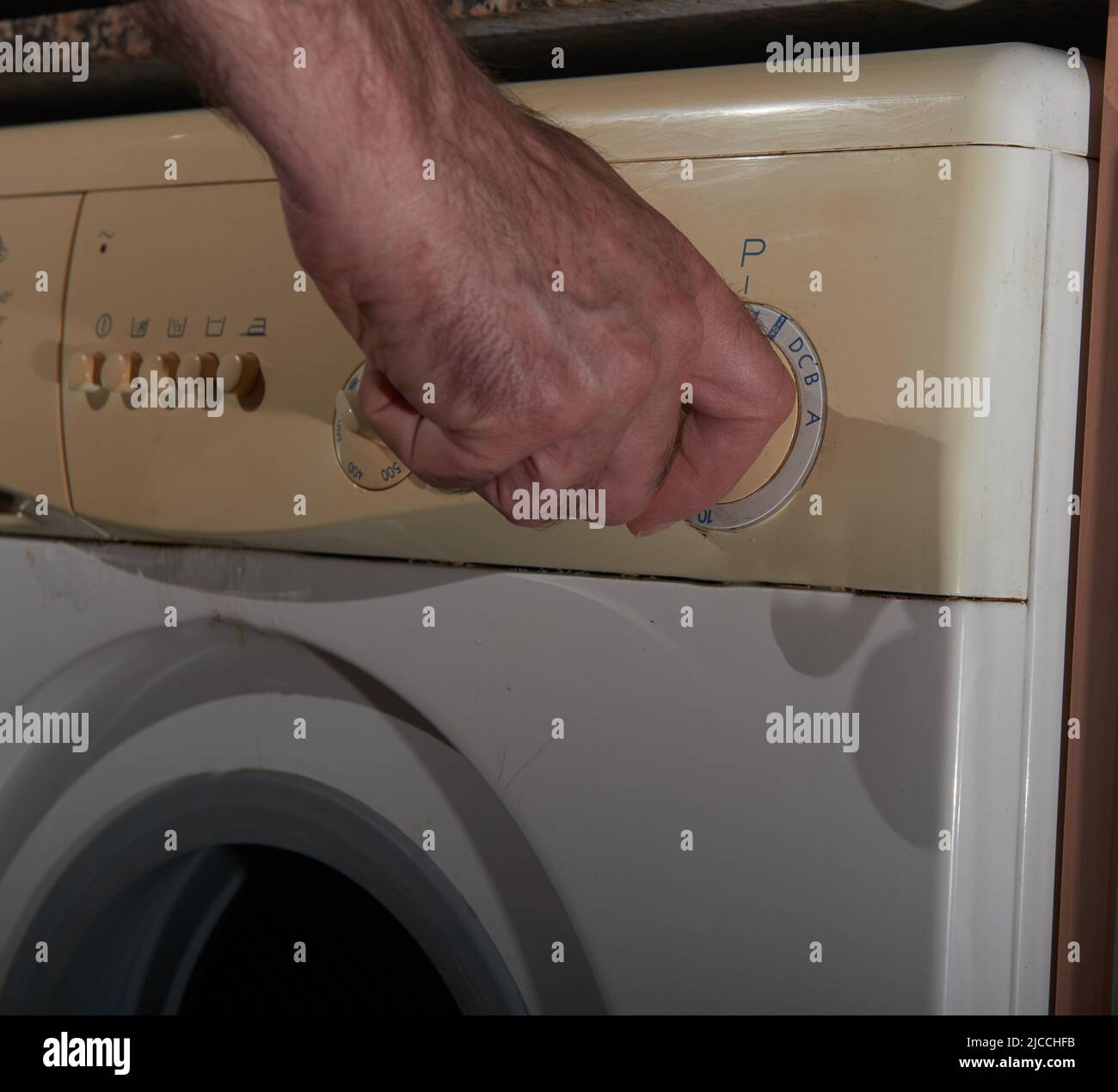 A man's hand starting up a washing machine Stock Photo - Alamy