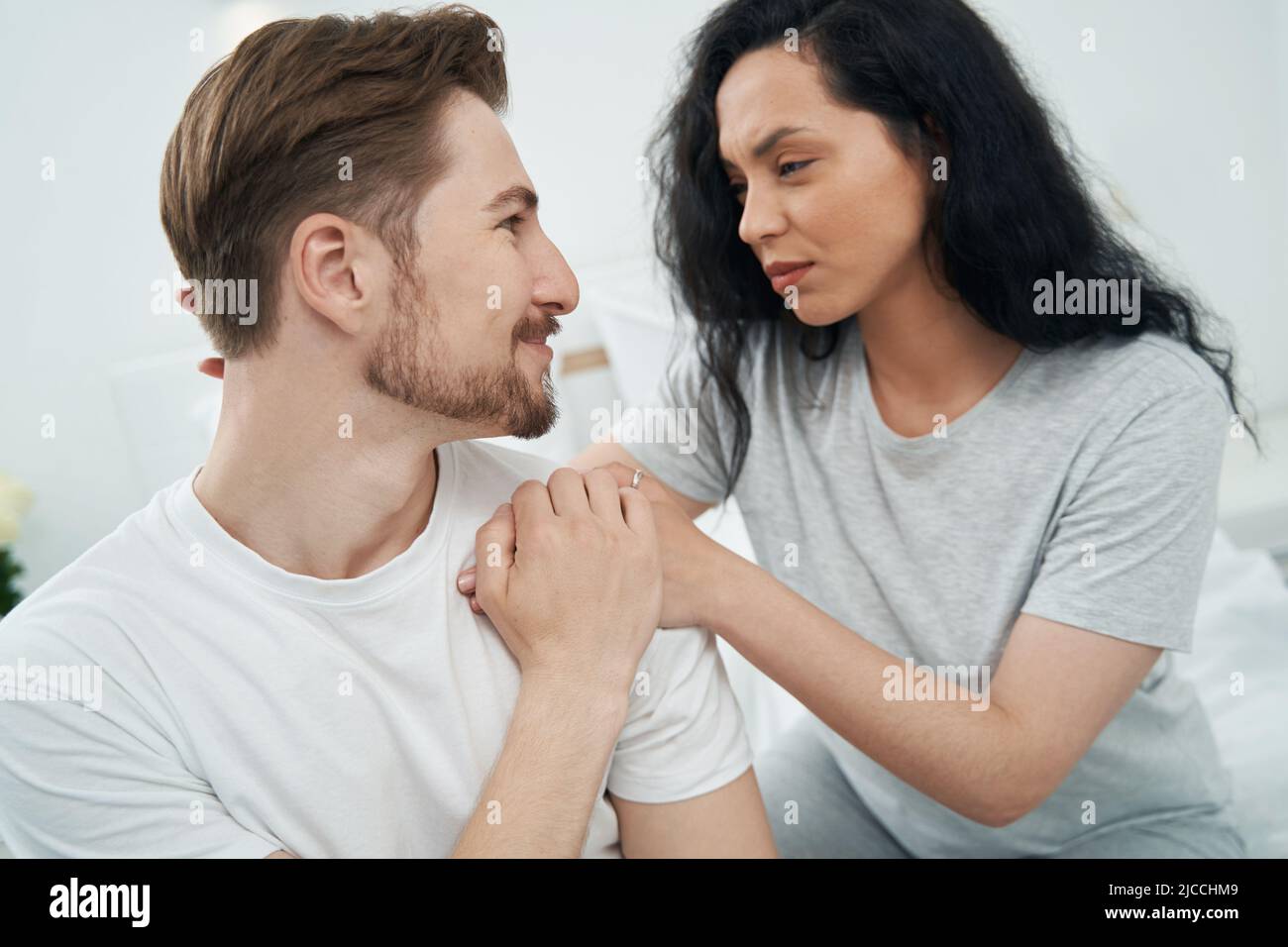 Couple seated in bed gazing at each other Stock Photo - Alamy