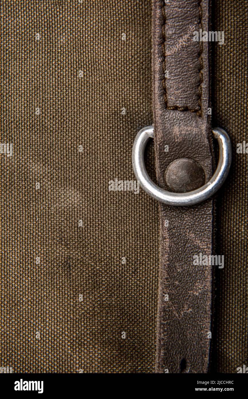 Close-up texture of a canvas fabric backpack. Leather straps and metal ...