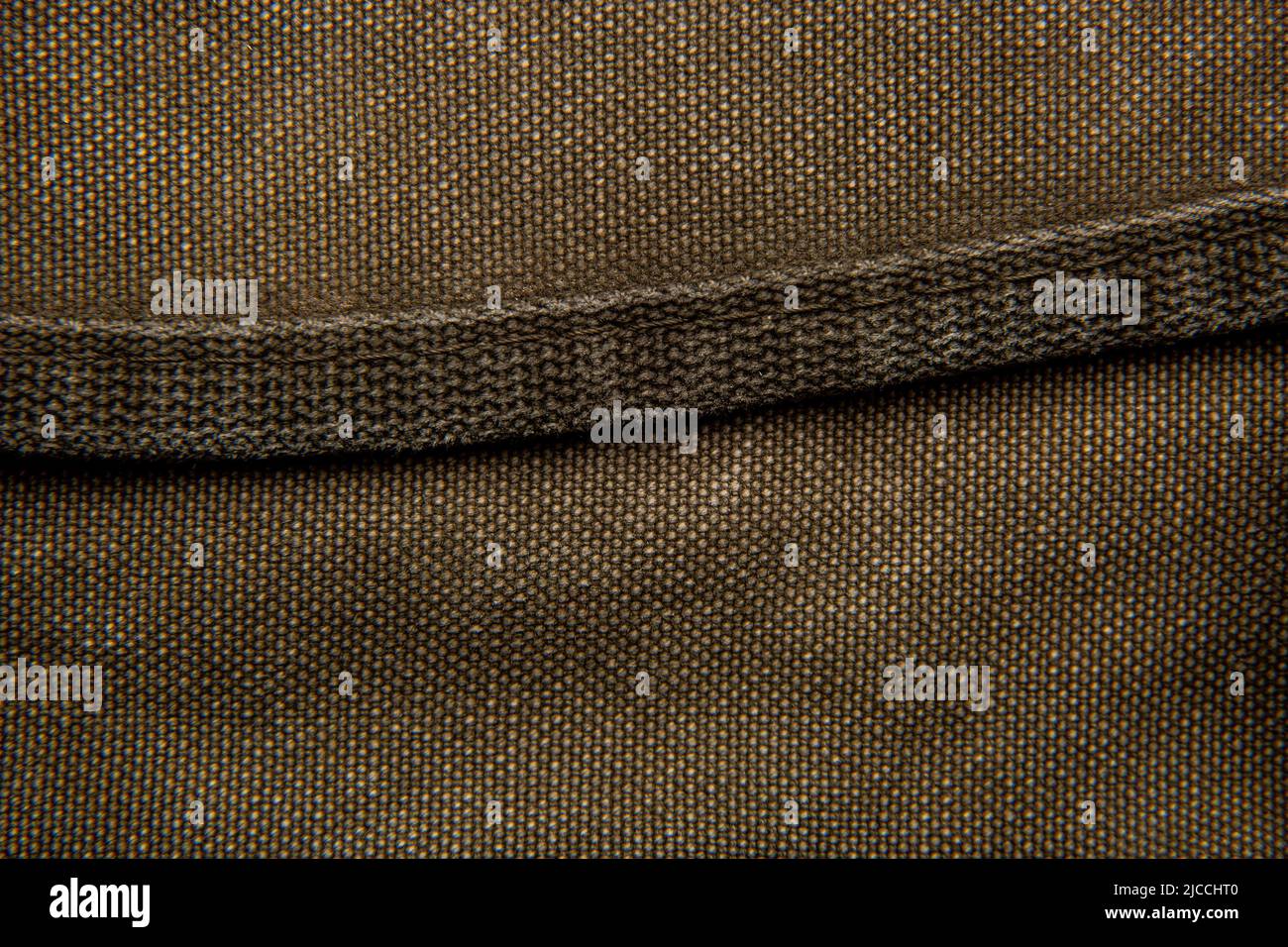 Close-up texture of a canvas fabric backpack. Leather straps and metal ...