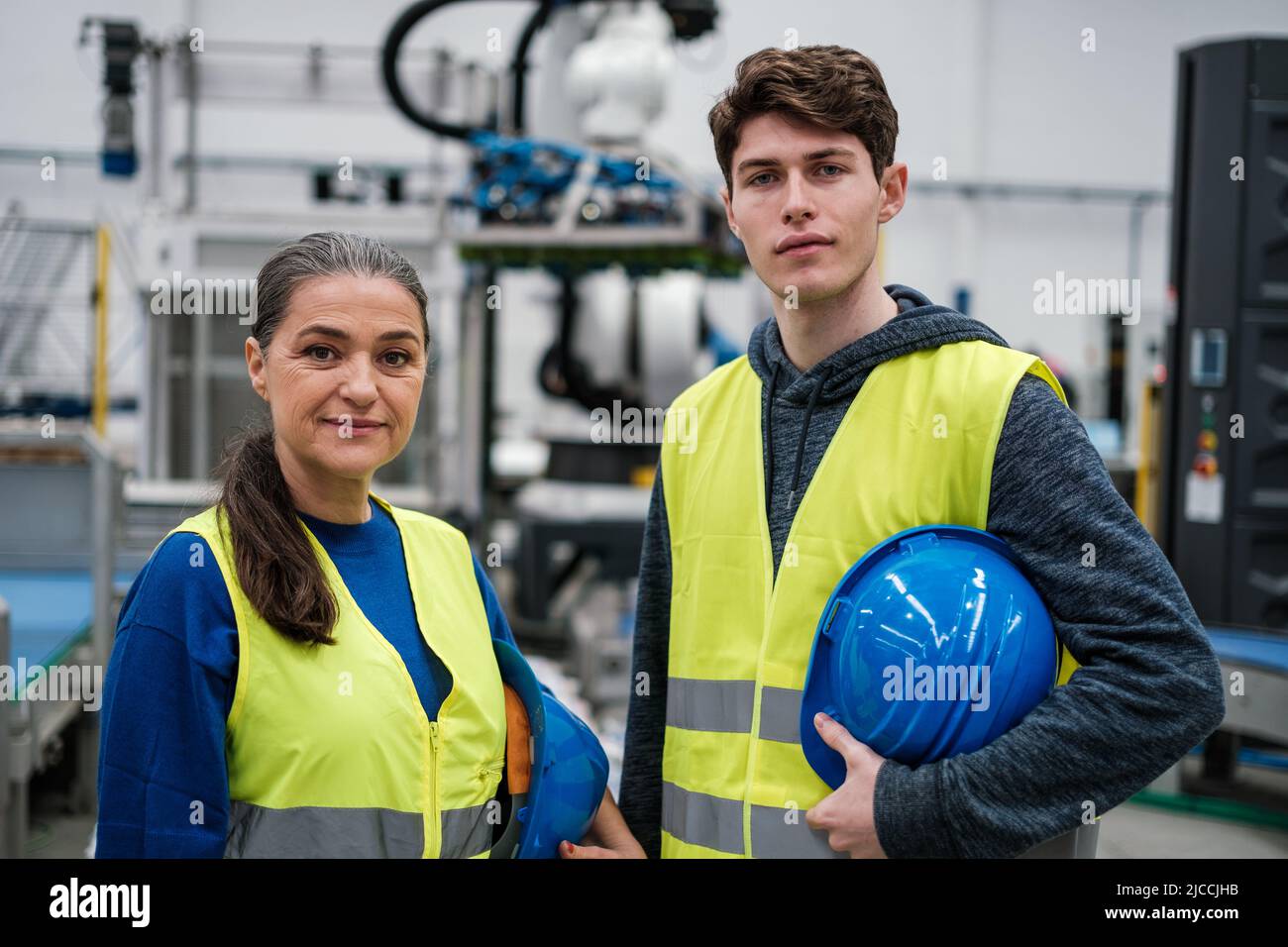 Two co-workers in the factory of different ages posing together Stock ...