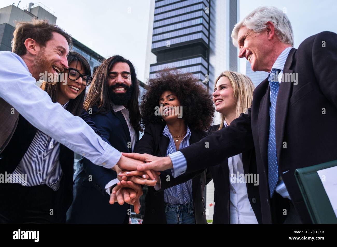Diverse group of coworkers putting hands together representing union ...