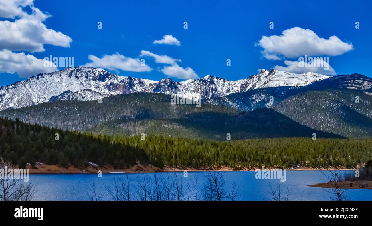 Pikes Peak panorama. Snow-capped and forested mountains near a mountain ...