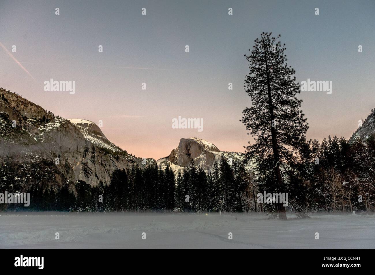 An eerie mist covers the floor of yosemite valley, while a thin layer ...