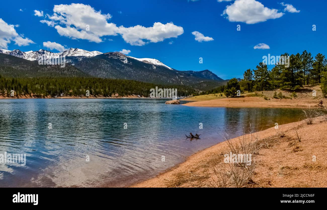 Pikes Peak panorama. Snow-capped and forested mountains near a mountain ...