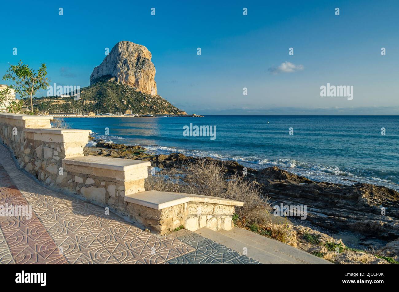 View of the beach of Calpe at sunset, with the Peñon de Ifach in the ...