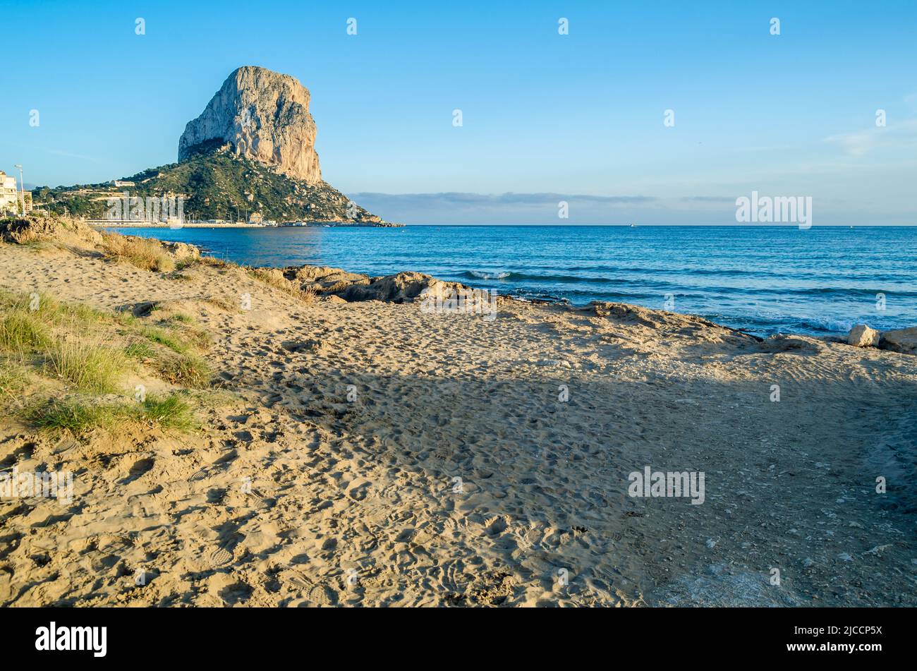 View of the beach of Calpe at sunset, with the Peñon de Ifach in the ...