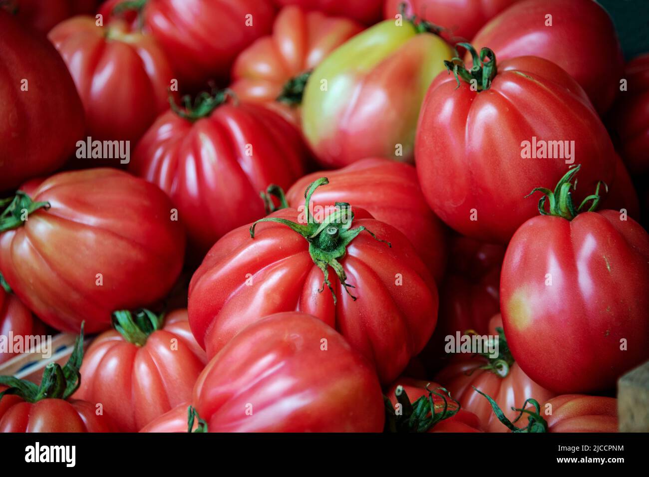 Big red tomatoes to sell on the central market of the city Stock Photo ...