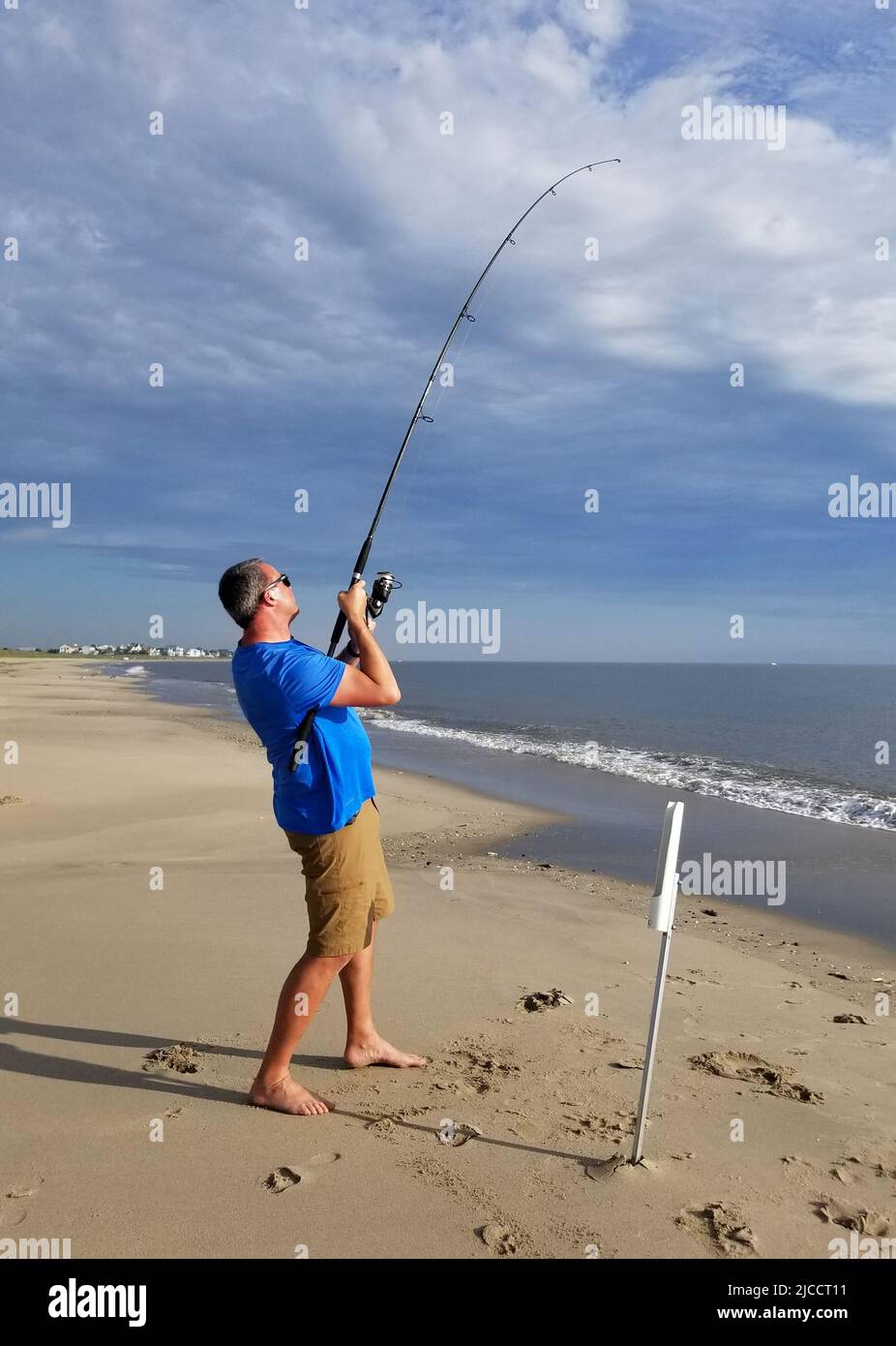 Broadkill Beach, Delaware, U.S.A - May 16, 2022 - A man reeling a big ...