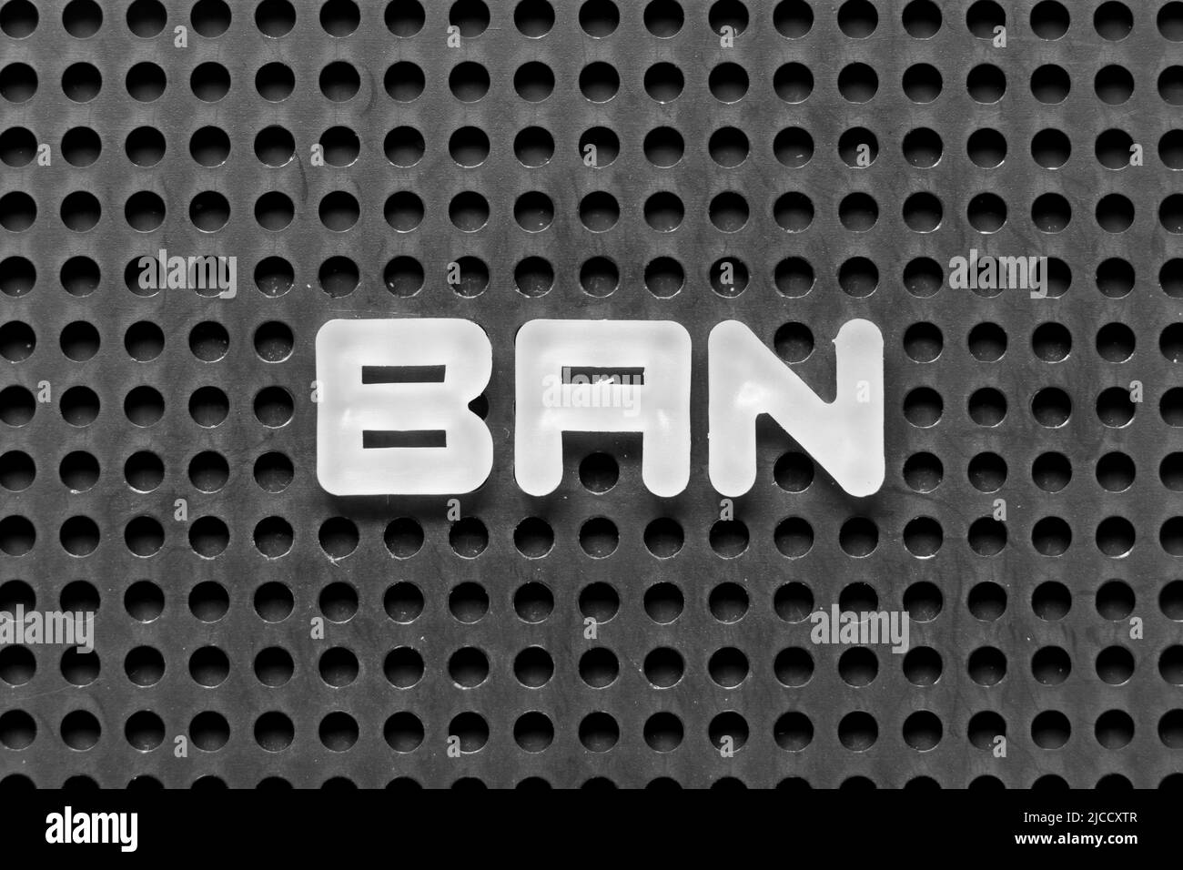 White alphabet letter in word ban on black pegboard background Stock ...