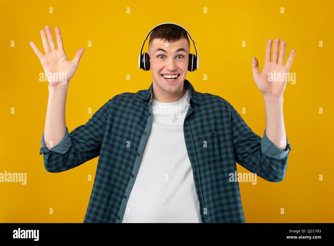 Happy Guy Wearing Earphones Listening Music Posing Over Yellow ...