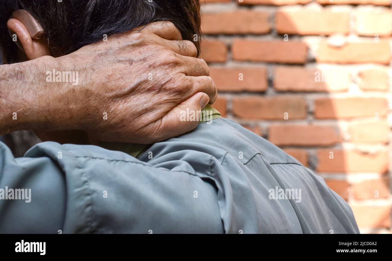 Pain in the neck muscle of Southeast Asian elder man. Concept of nape ...
