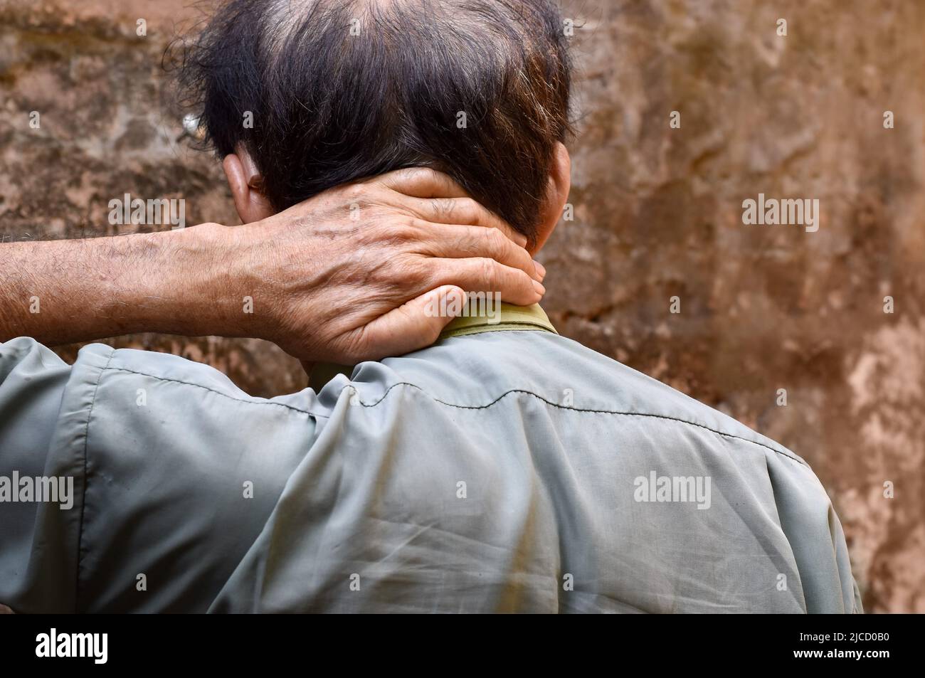 Pain in the neck muscle of Southeast Asian elder man. Concept of nape ...