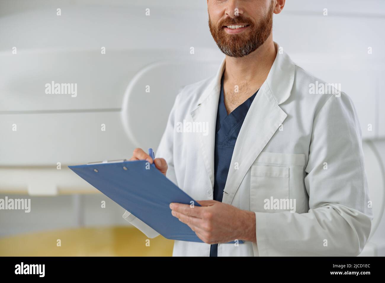 Close up of Radiologist making notes on clipboard on backgraund of MRI ...