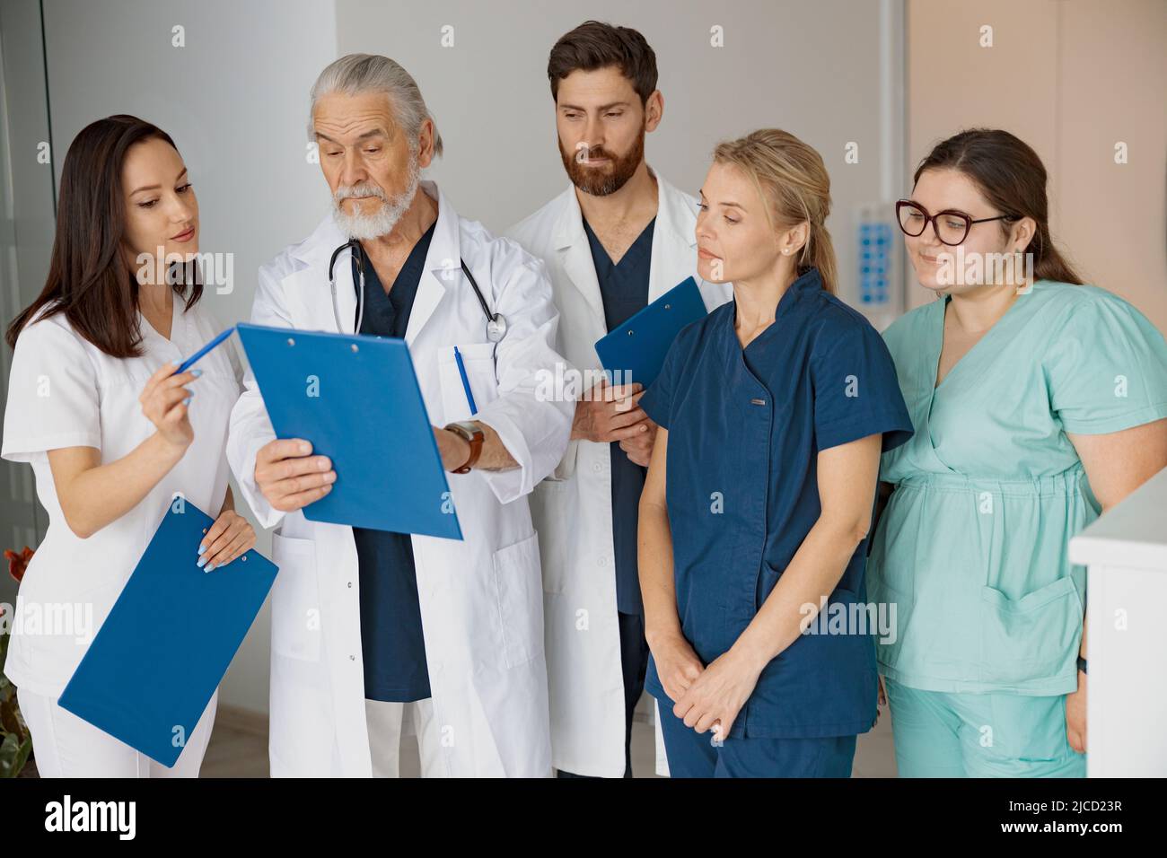 Doctor giving lecture to interns in hospital discussing patient ...