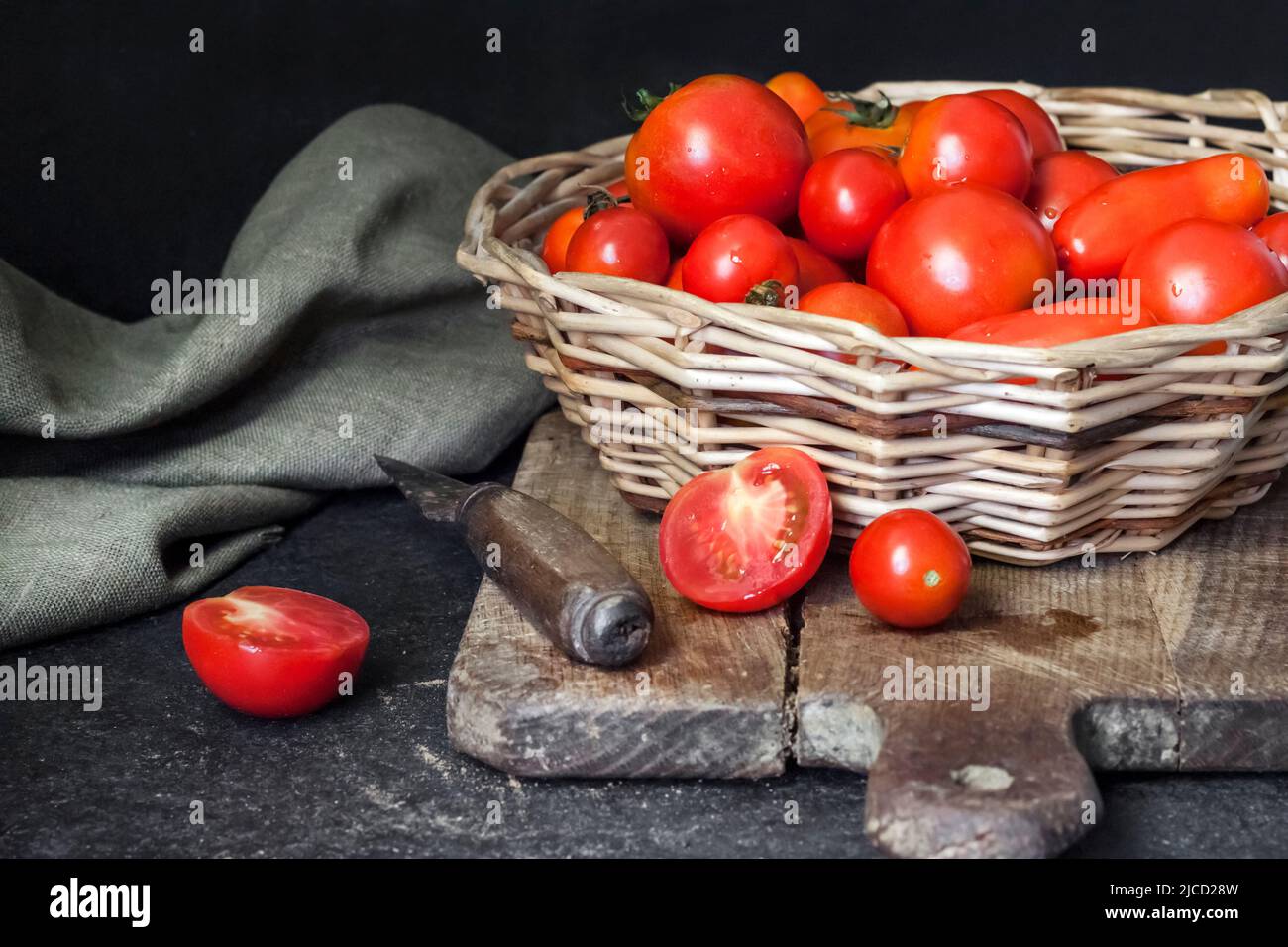 Fresh red tomatoes in whicker basket on black background Stock Photo ...