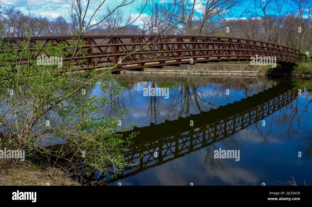 Metal bridge over the canal, reflection of the bridge in the water ...