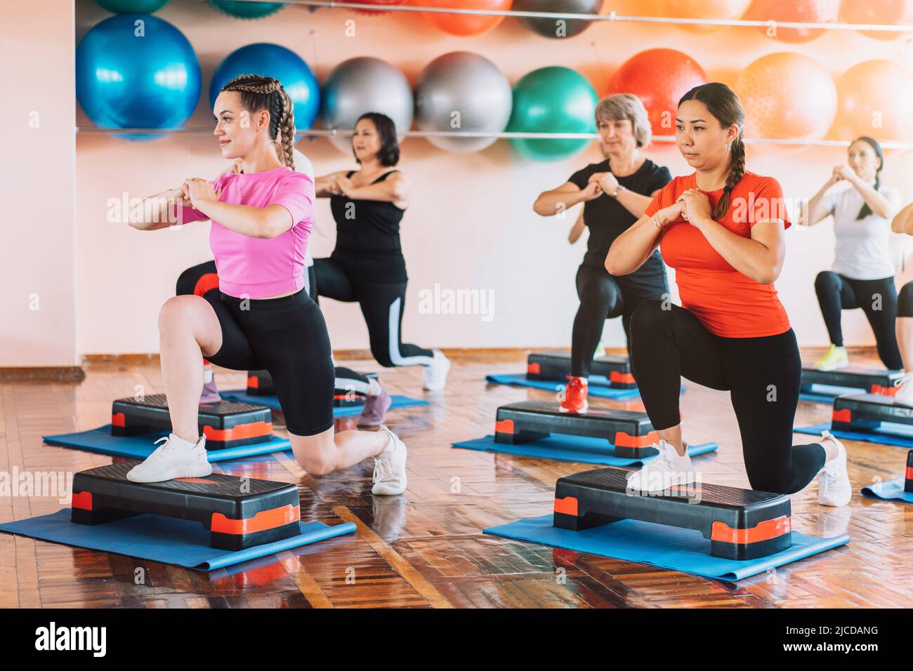 Group of women doing step aerobics indoors Stock Photo - Alamy