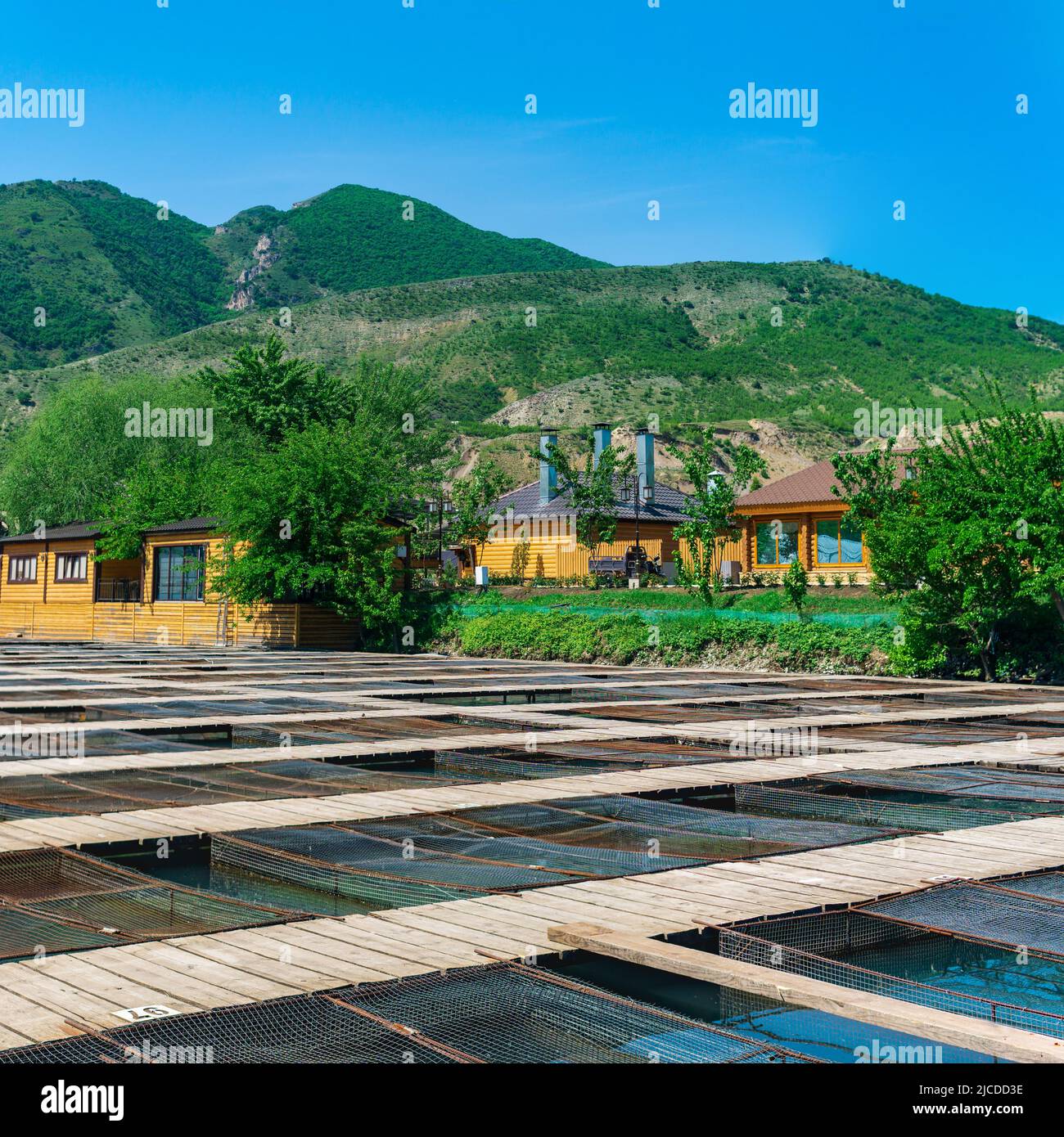 fish farm in a mountain valley with aquaculture cages and wooden ...