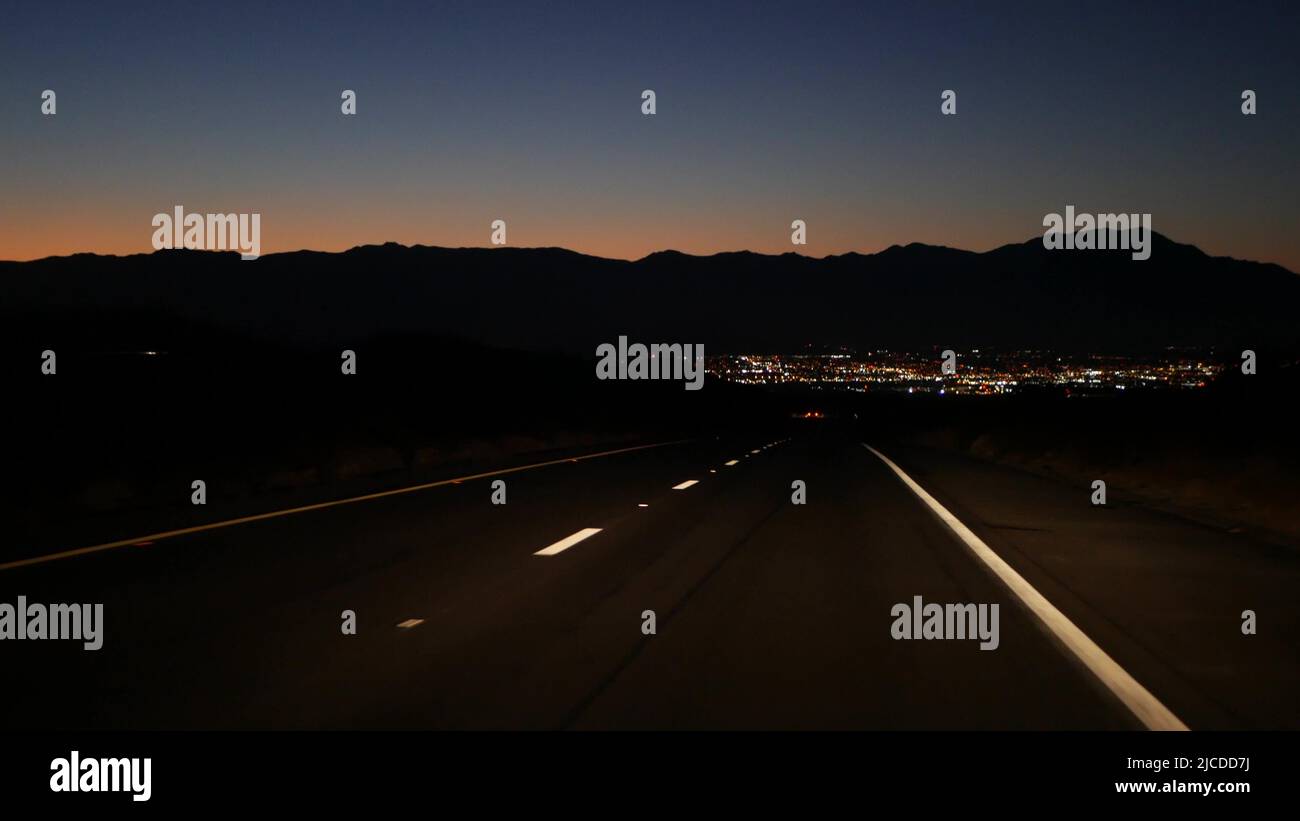 Car driving on desert road at night, freeway or highway in twilight ...