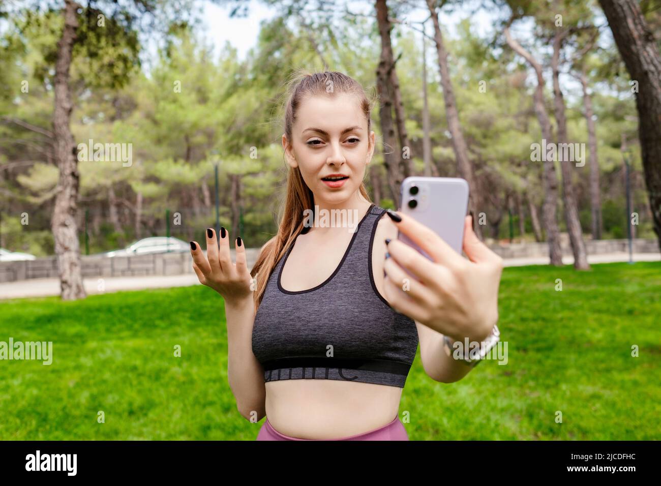 Young brunette woman wearing sportive clothes on city park, outdoors ...
