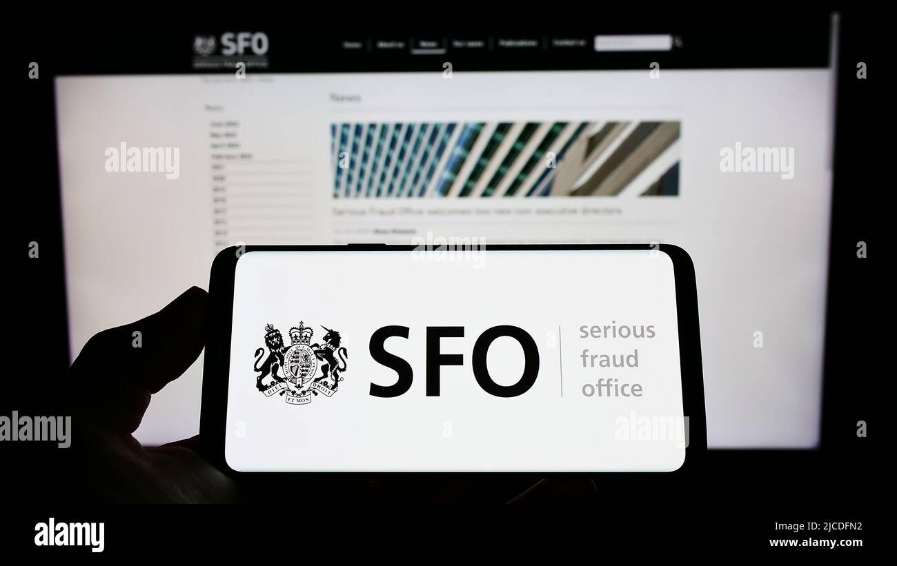 Person holding cellphone with logo of British agency Serious Fraud ...