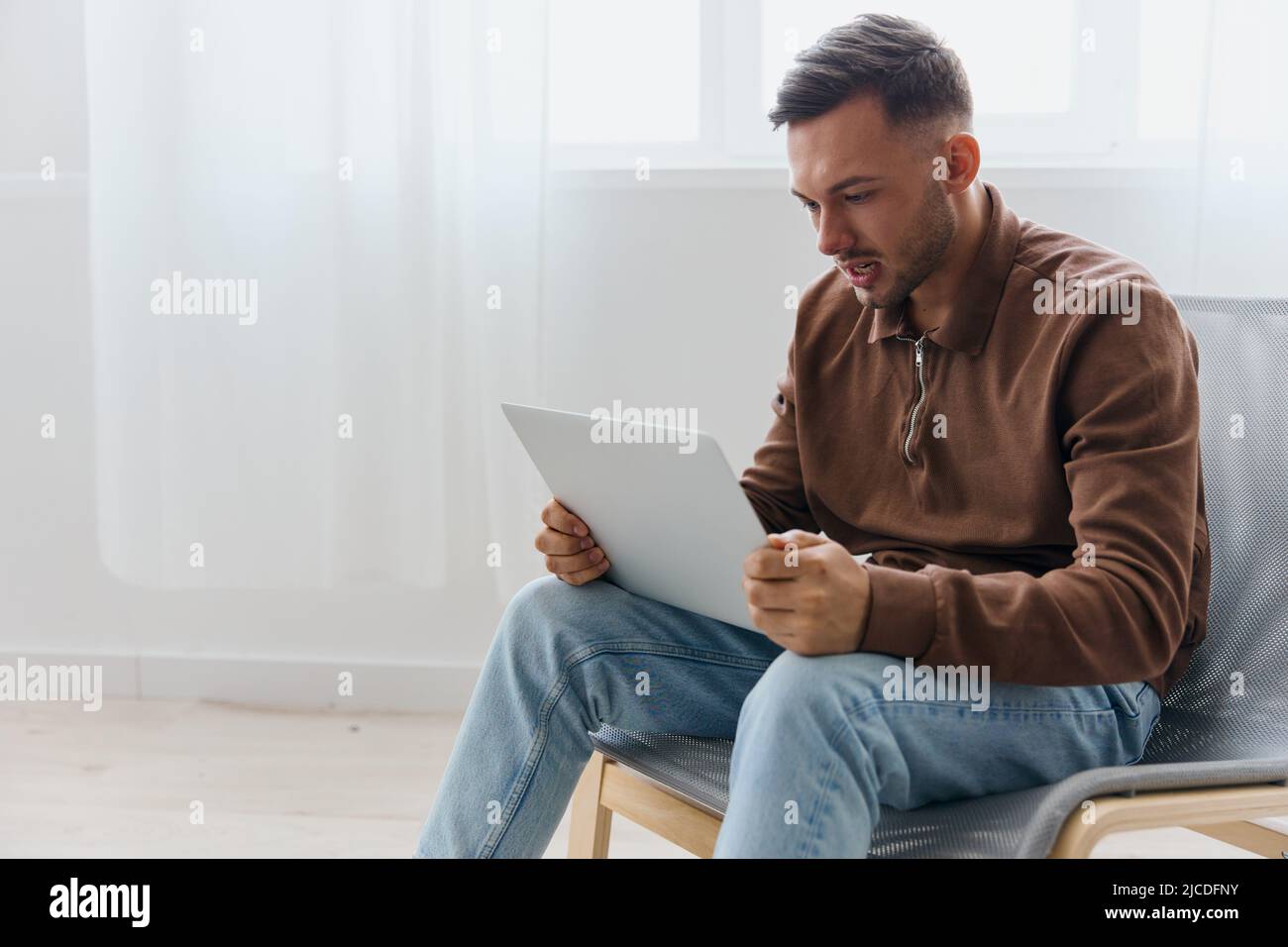 PC software failure concept. Angry aggressive irritated young man hold ...