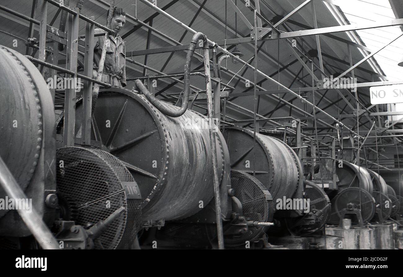 1960s, historical, inside a paint manufacturing factory, a male ...