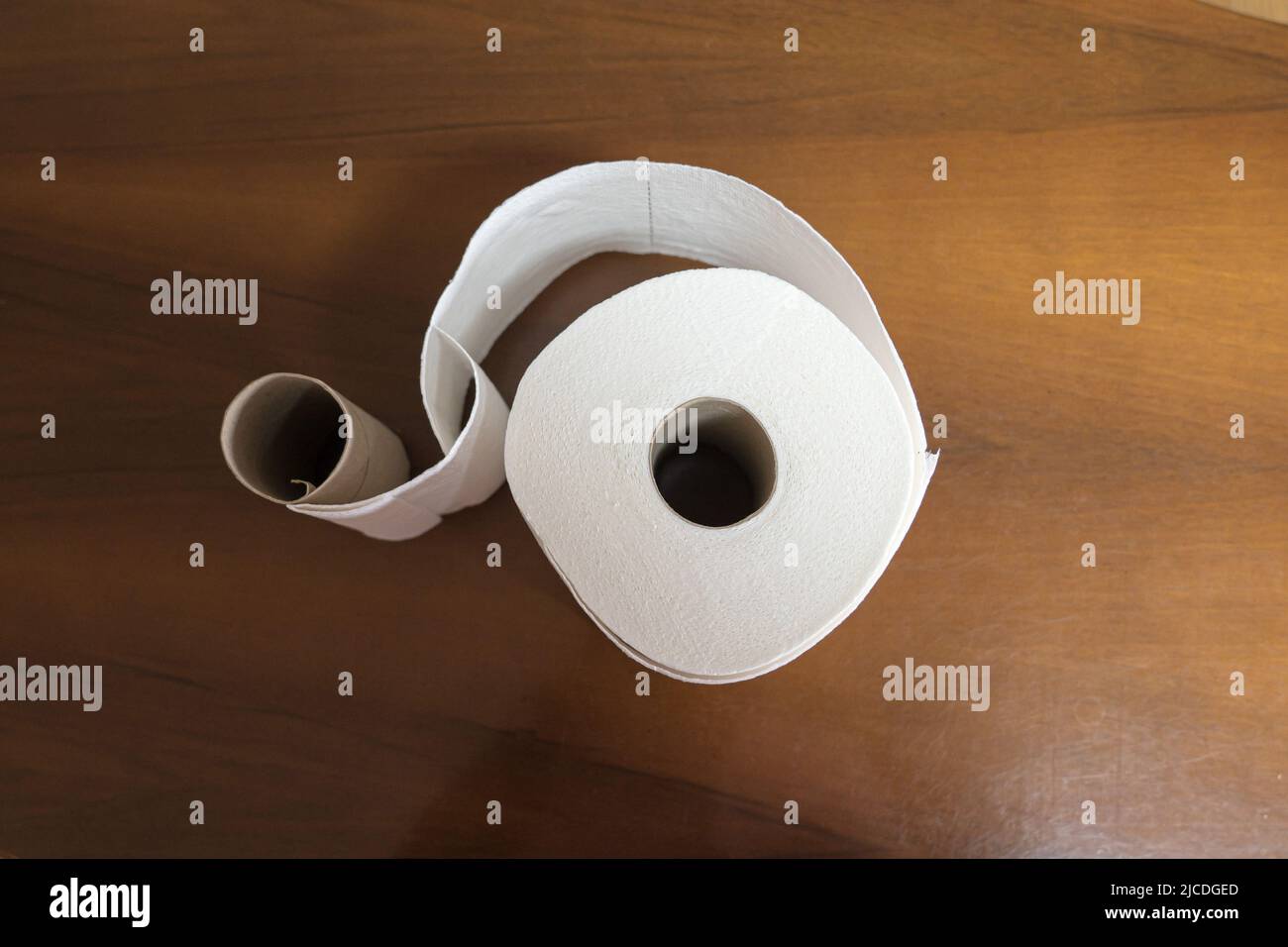 top view of an empty toilet paper roll intertwined with a new toilet ...