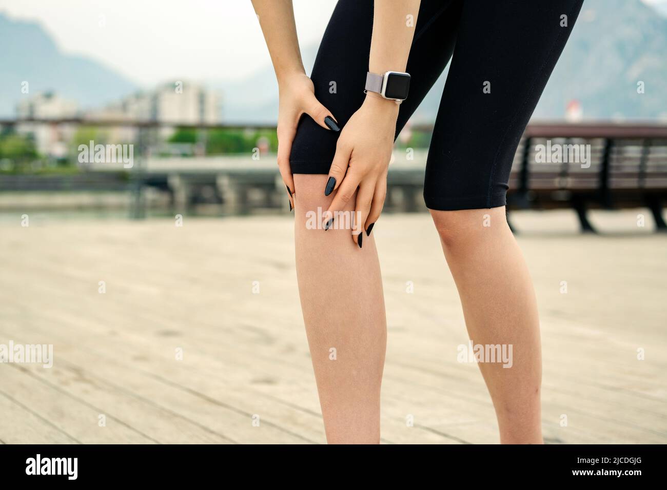 Brunette sportive woman wearing black sports bra standing on city park ...
