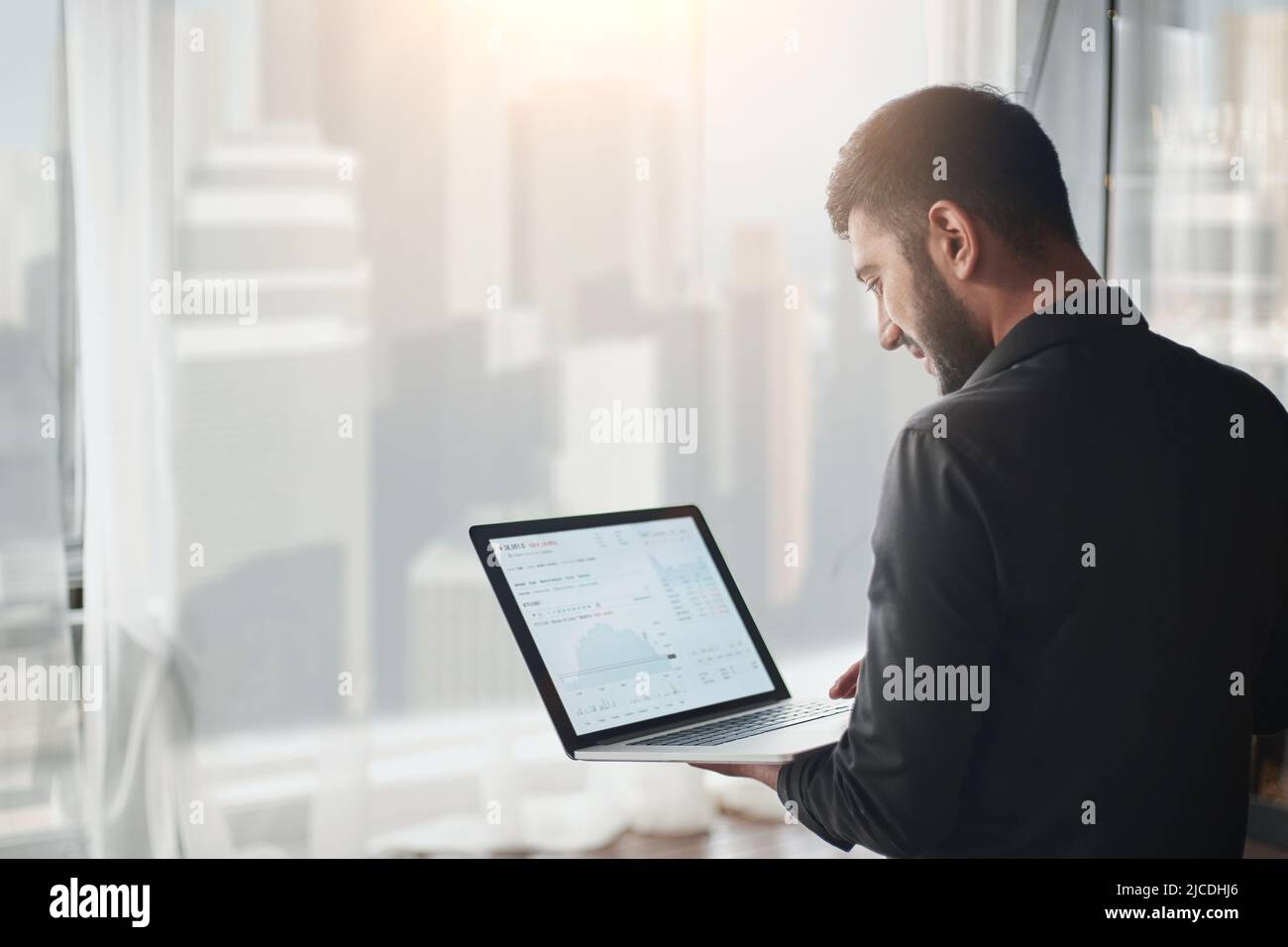 business owner with a laptop standing near the window Stock Photo - Alamy